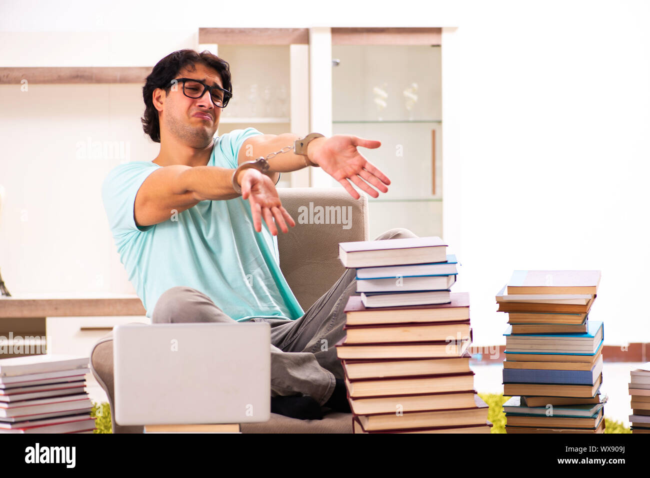 Male student with many books at home Stock Photo - Alamy