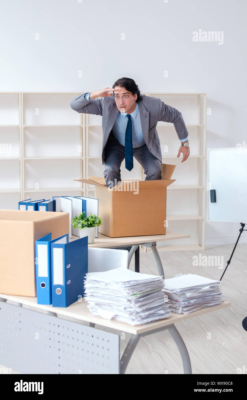 Young man employee with boxes in the office Stock Photo - Alamy