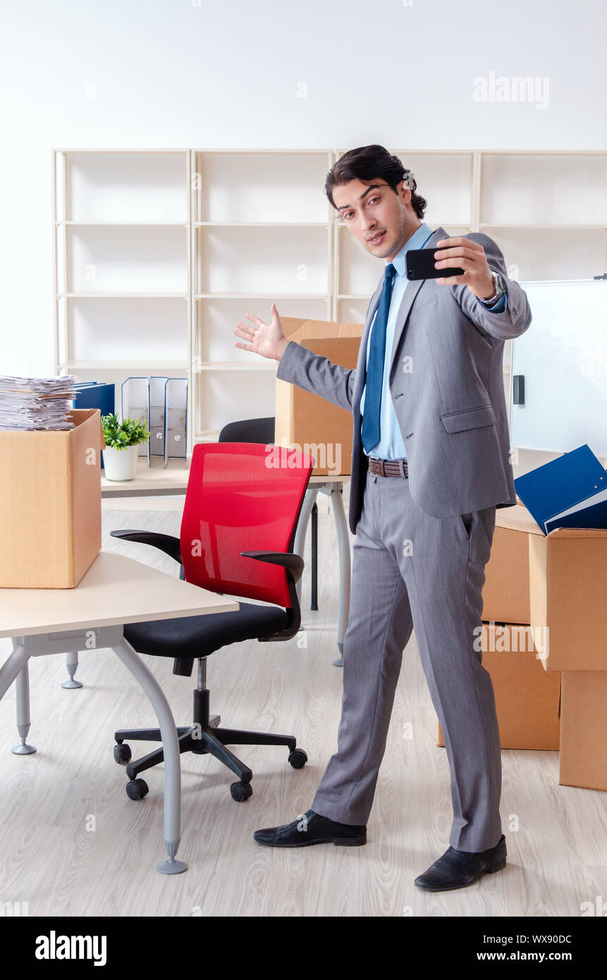 Young man employee with boxes in the office Stock Photo - Alamy