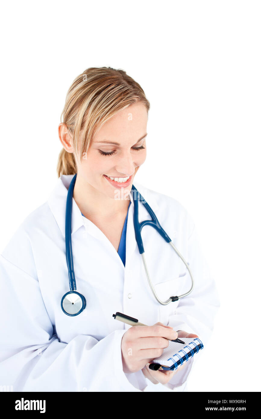 Concentrated female doctor taking notes on her notepad against a white ...