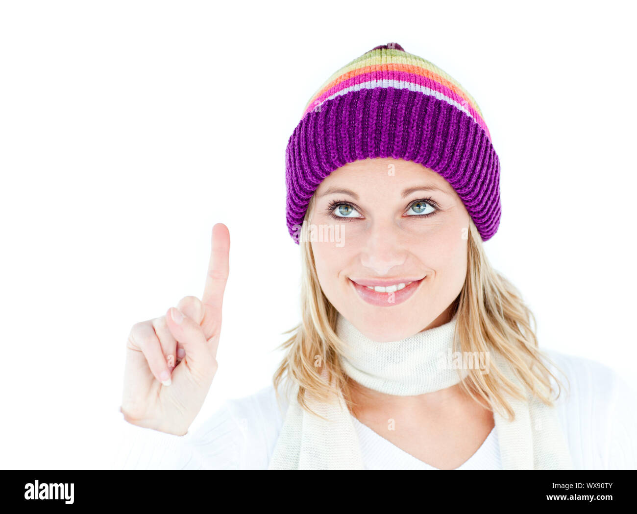 Pretty woman with a colorful hat pointing upwards against a white ...
