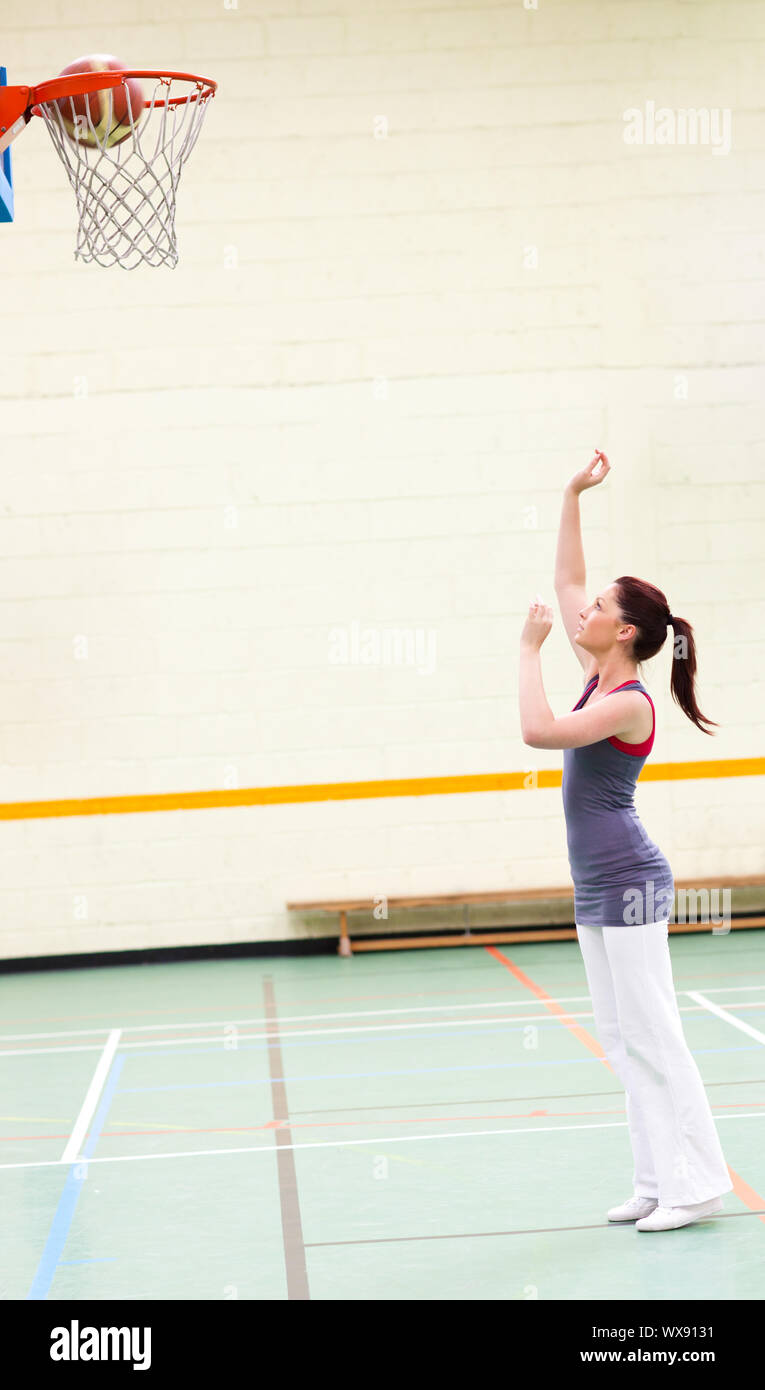 Gifted woman practicing basketball in a gymnasium Stock Photo - Alamy