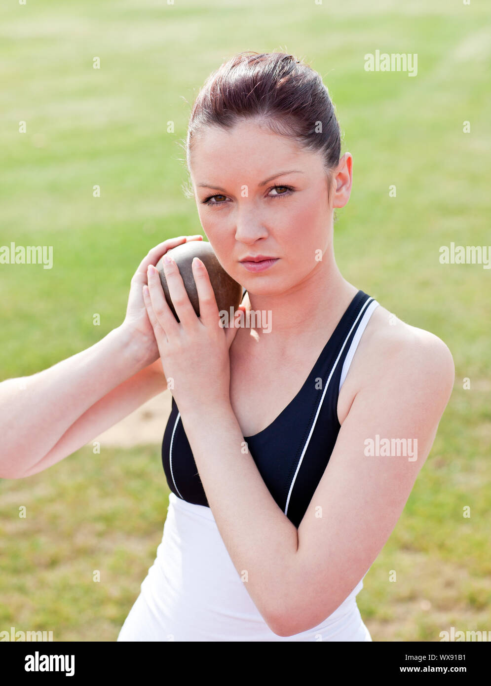 Determined female athlete ready to throw weight in a stadium Stock ...
