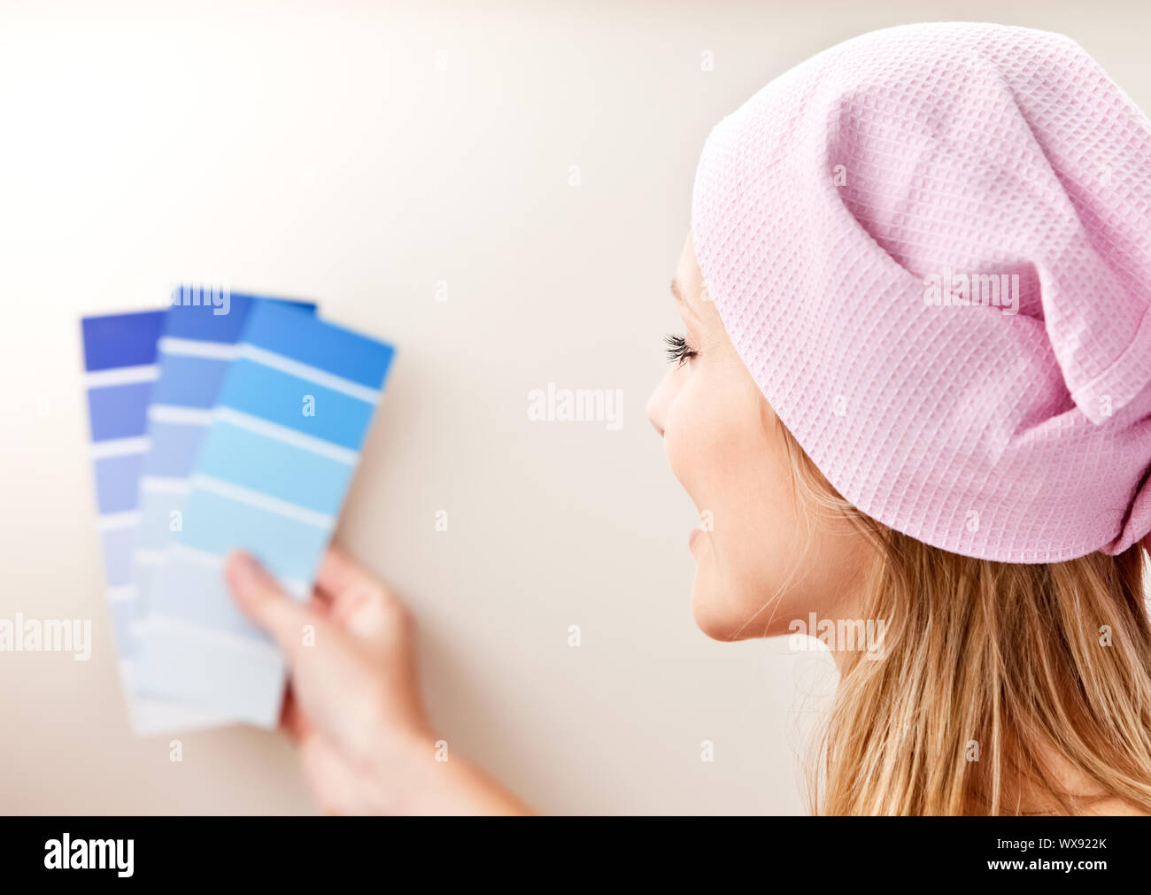 Attractive young woman choosing color for painting a room in her new ...