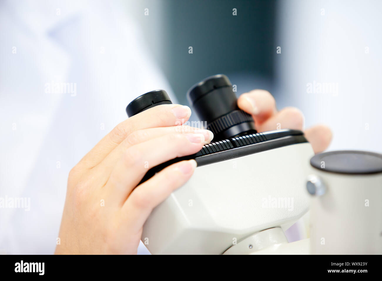 Close-up of a female scientist looking through a microscope in her ...