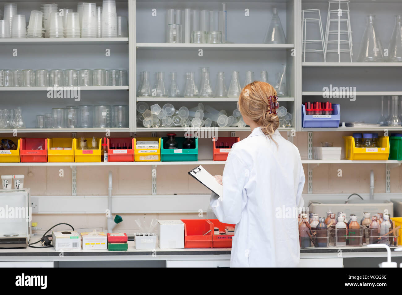 Serious female scientist writing on her clipboard in a laboratory Stock ...