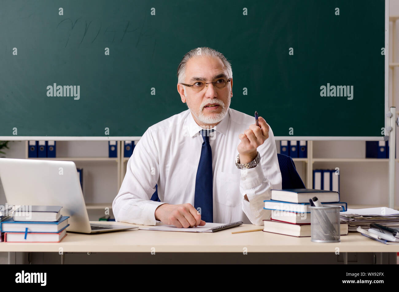 Aged male teacher in front of chalkboard Stock Photo - Alamy