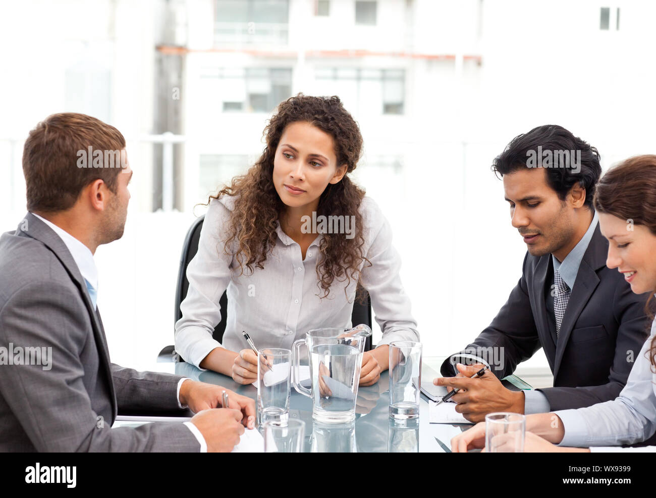 Beautiful manager speaking with her team during a meeting at the office ...