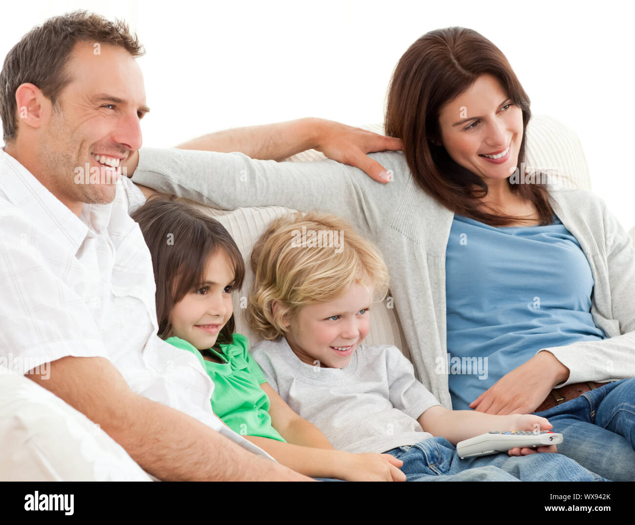 Parents and children watching television together on the sofa Stock ...