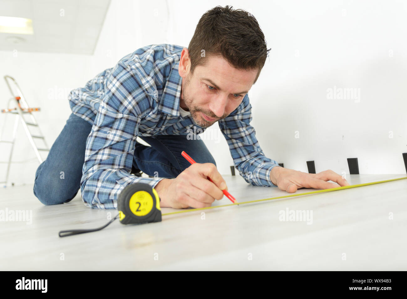 man measuring wood with tape measure Stock Photo - Alamy