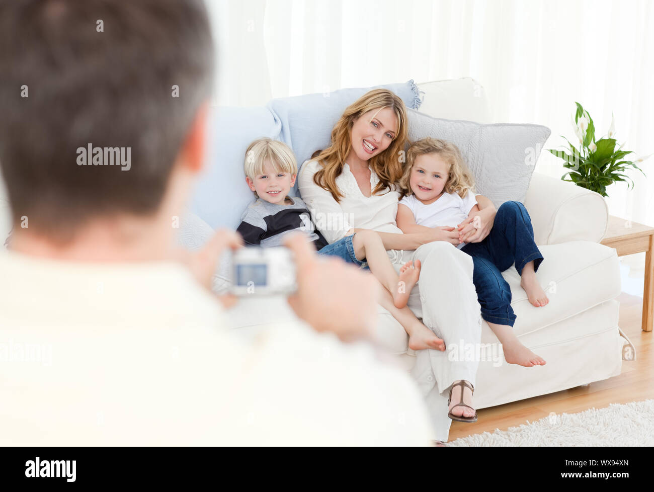 Man taking a photo of his family at home Stock Photo - Alamy