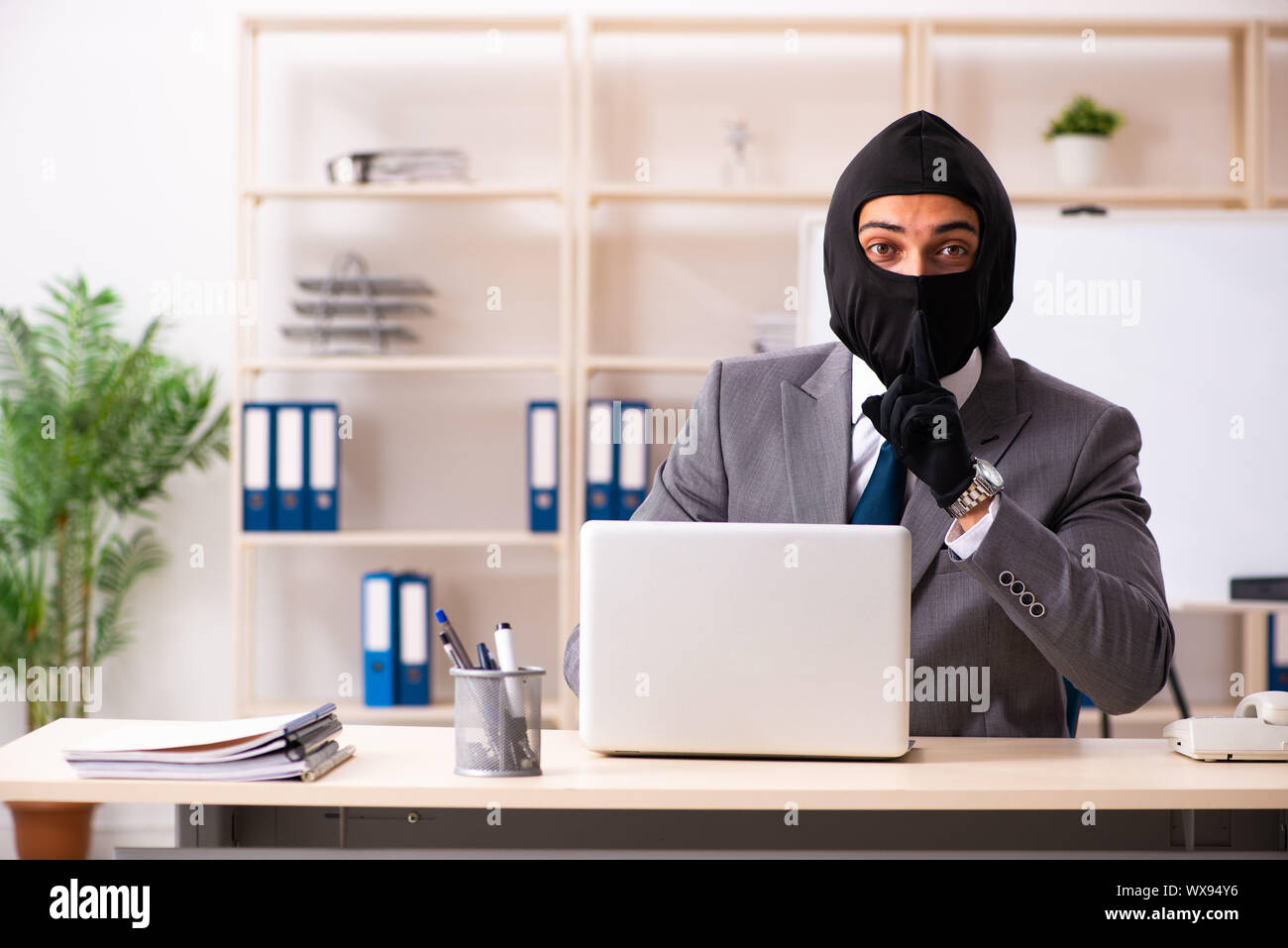 Male gangster stealing information from the office Stock Photo - Alamy