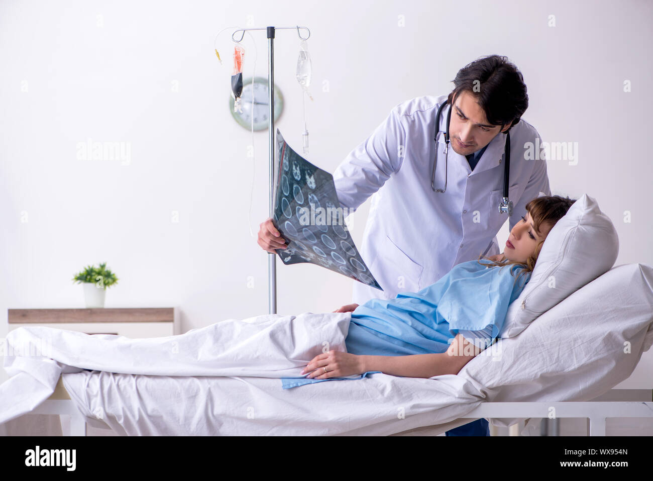 Male doctor visiting female patient in ward Stock Photo - Alamy