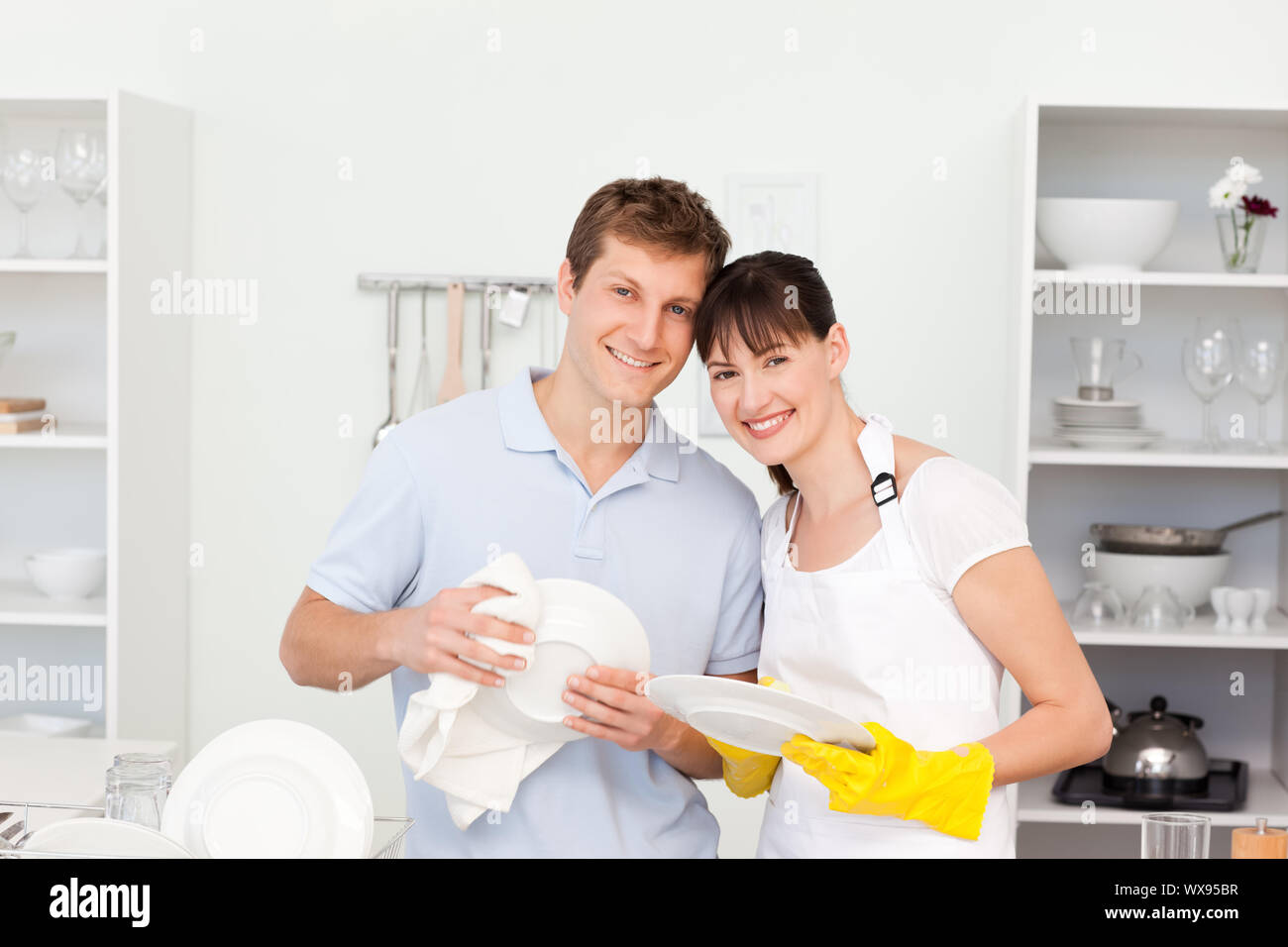 Couple washing dishes together in the kitchen Stock Photo - Alamy