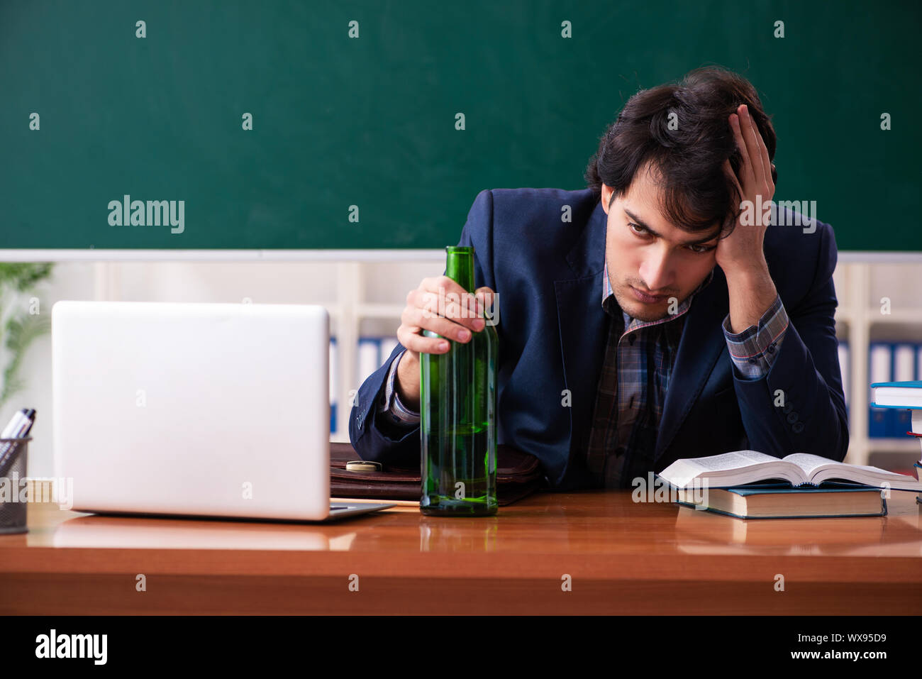 Male teacher drinking in the classroom Stock Photo - Alamy