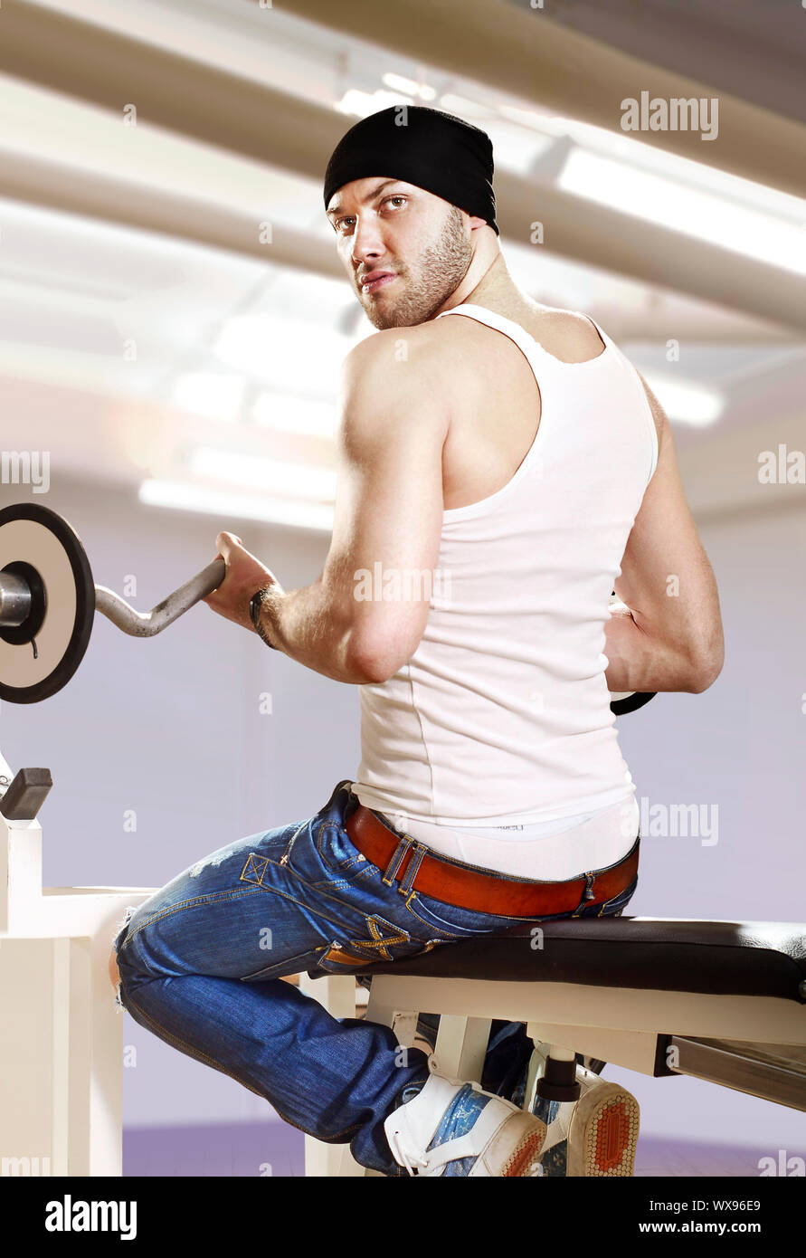 man makes exercises with bar in exercise room Stock Photo - Alamy