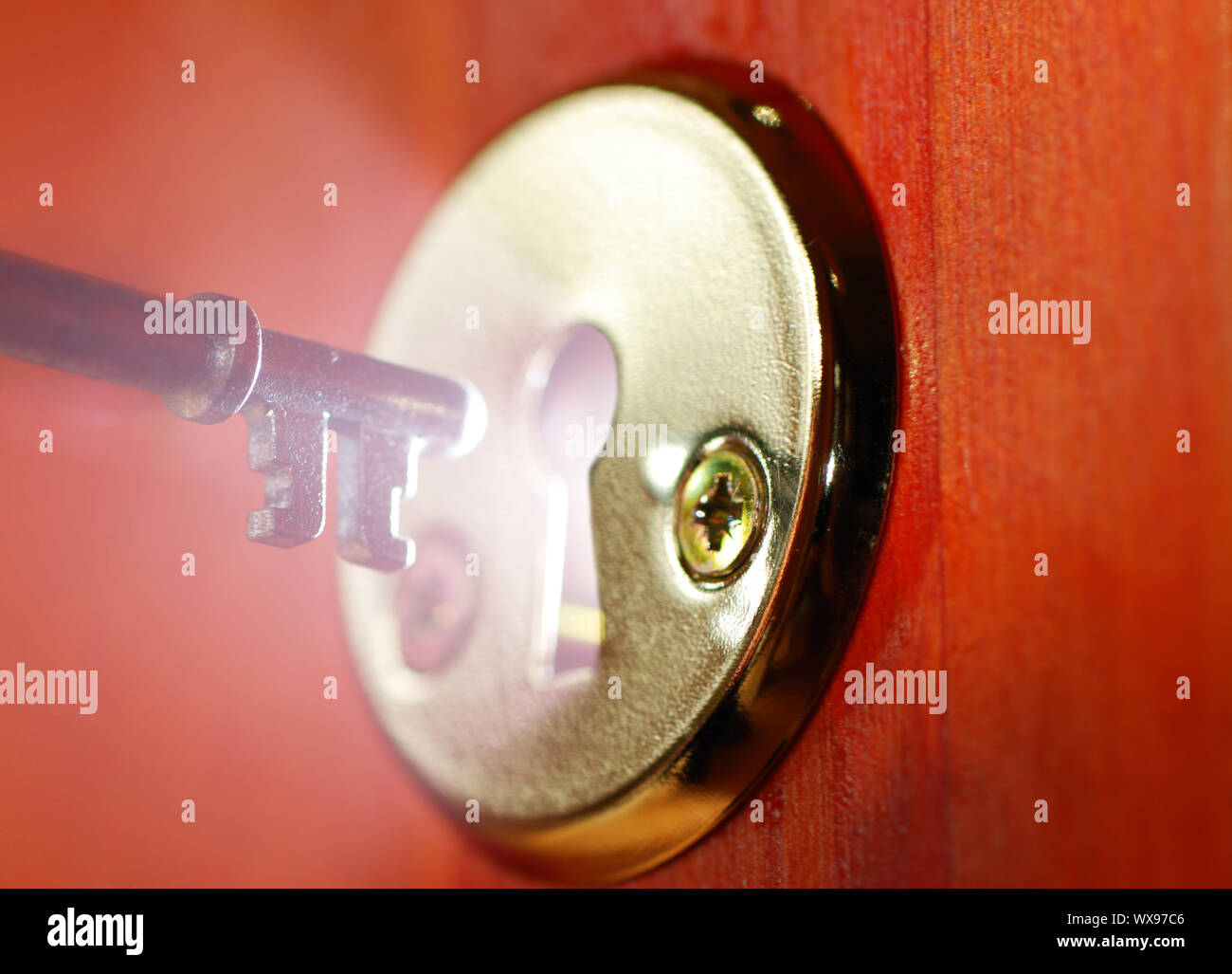Key and keyhole with light coming from it Stock Photo - Alamy