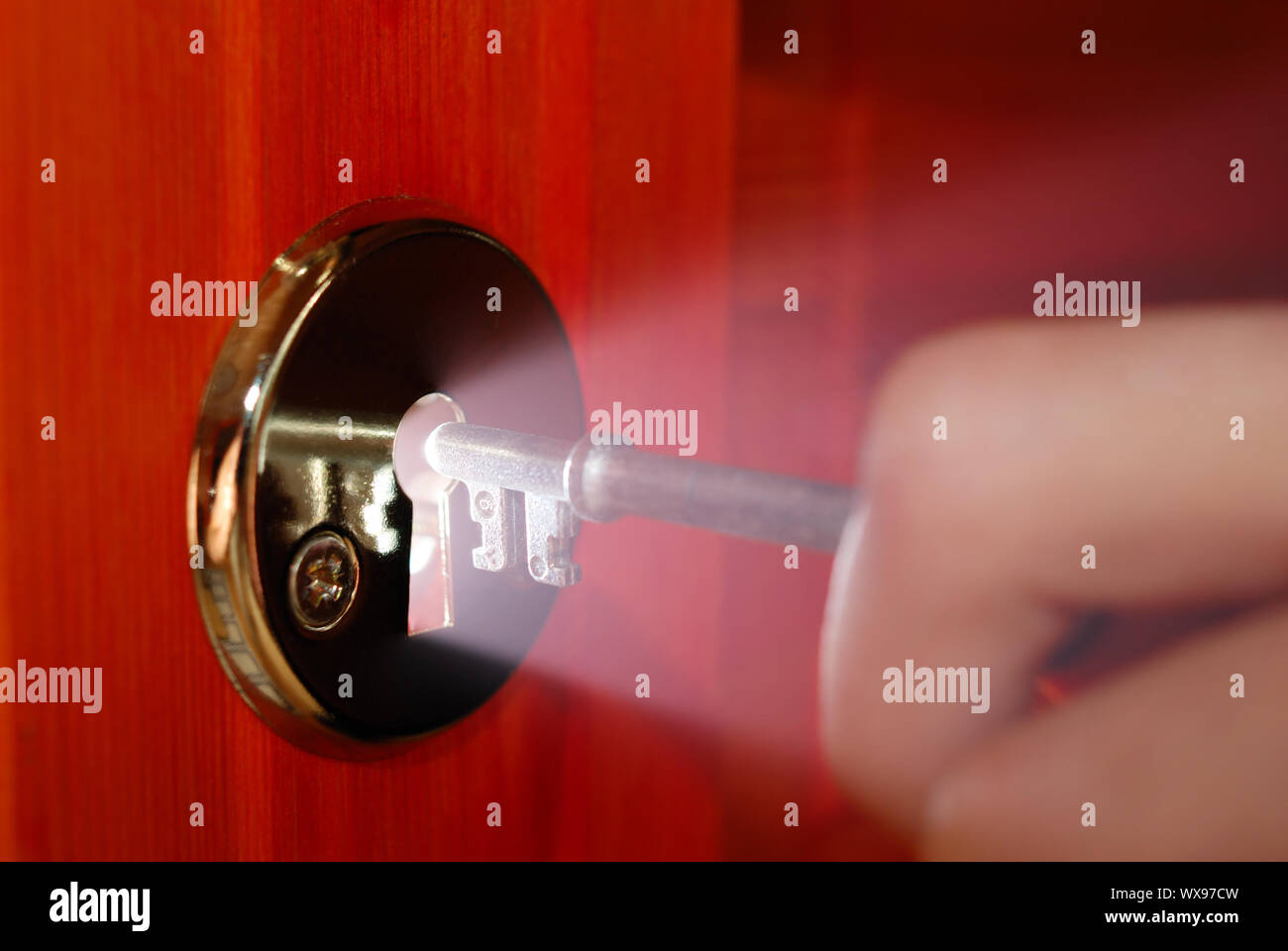 Key and keyhole with light coming from it Stock Photo - Alamy