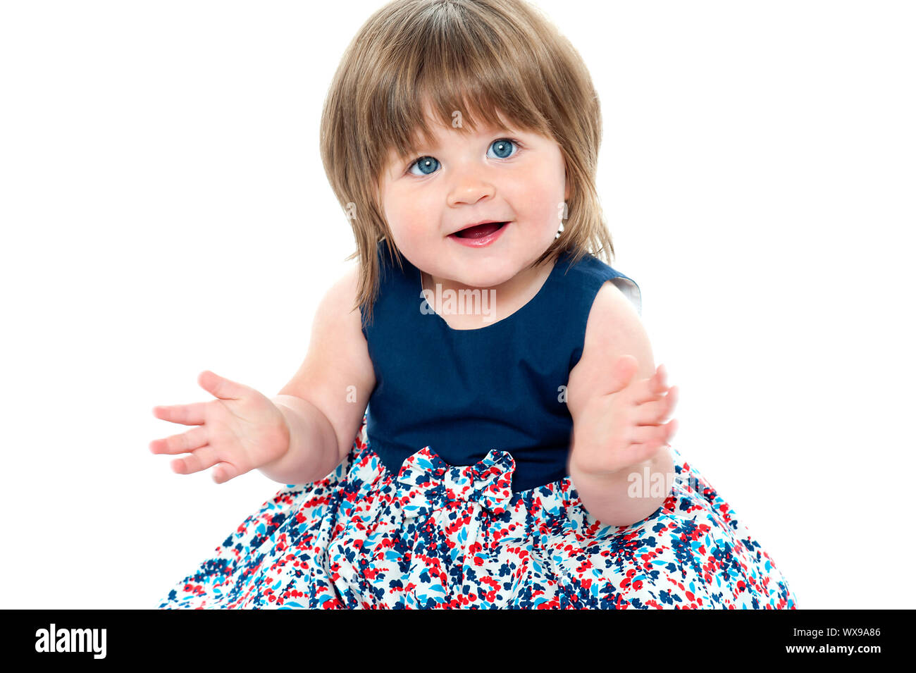 Chubby little toddler wearing dotted blue frock. Clapping cutely Stock ...