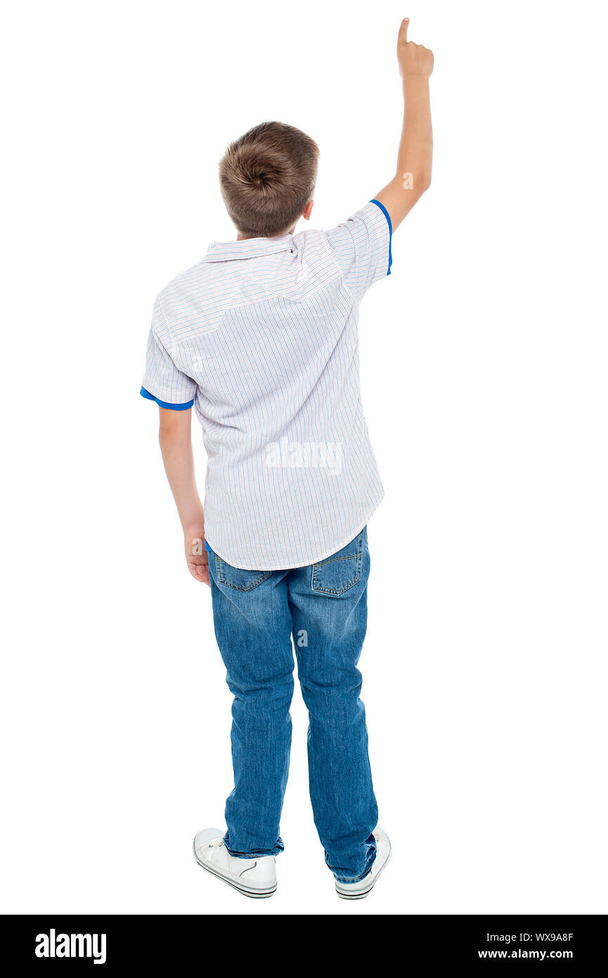 Rear view of a school boy over white background pointing upwards. Full ...