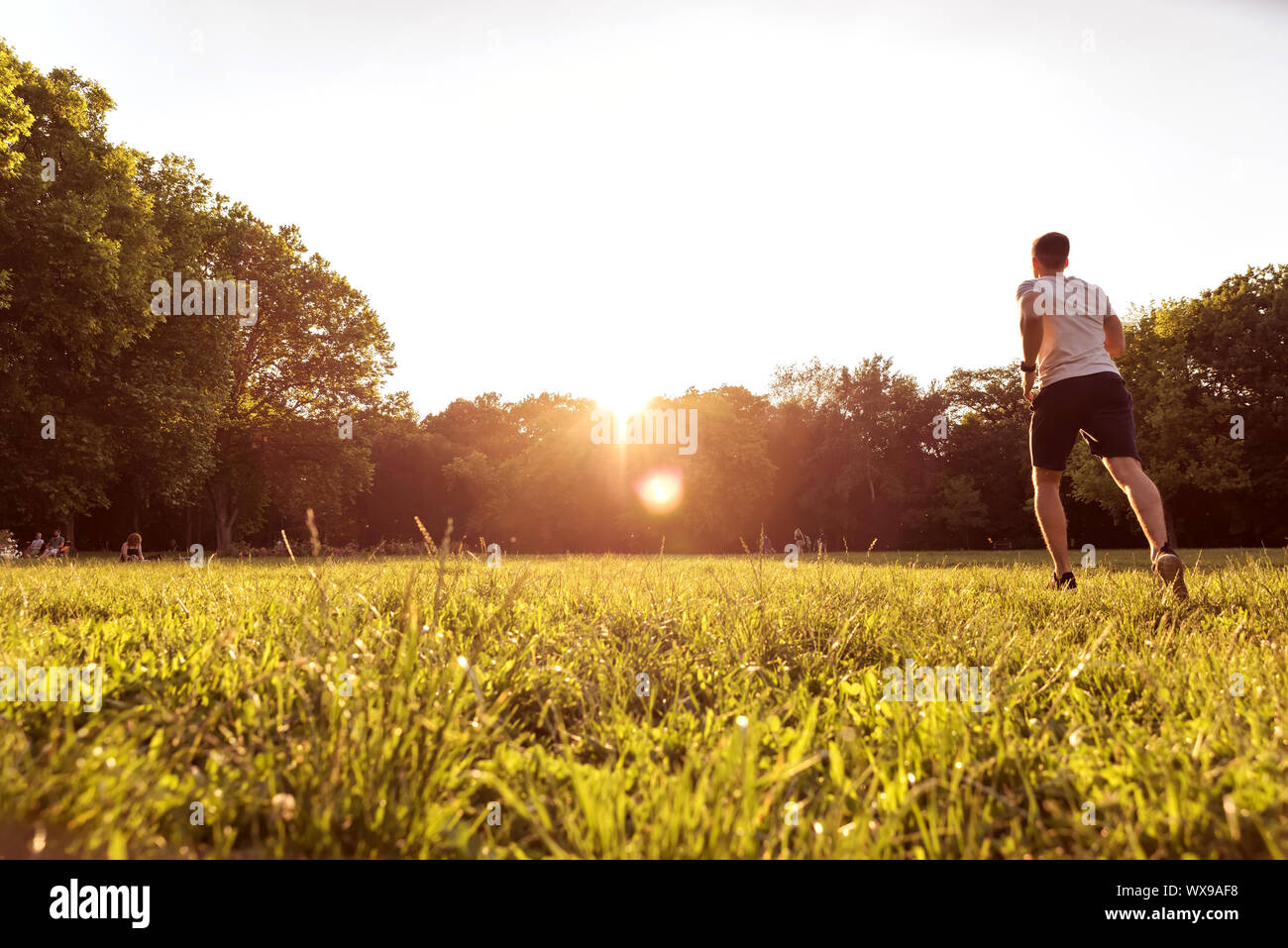 A handsome young man running towards the sunset Stock Photo - Alamy