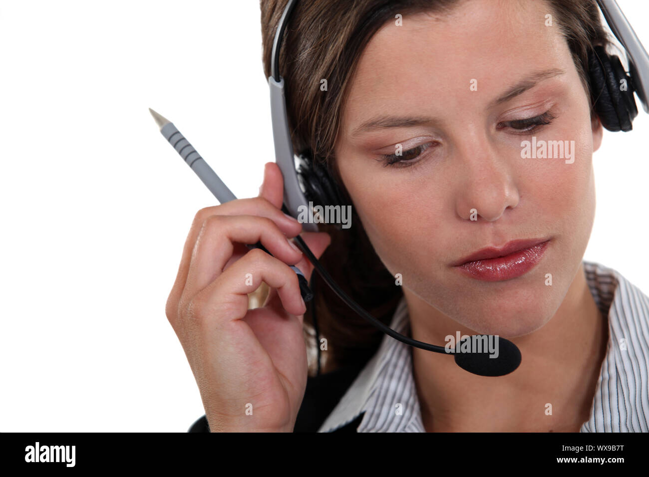 Brunette call-center worker listening to customer Stock Photo - Alamy