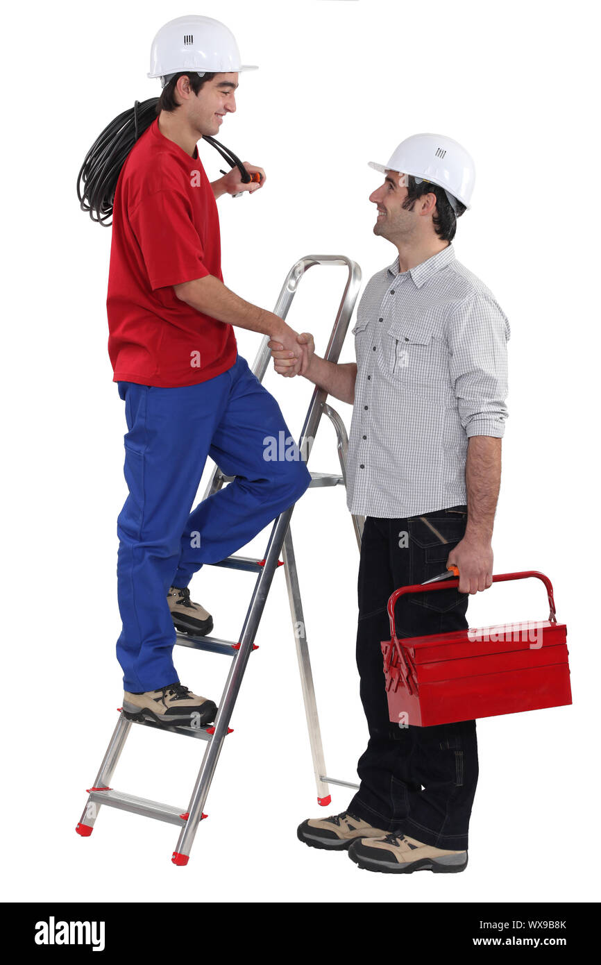 Two manual workers shaking hands Stock Photo - Alamy