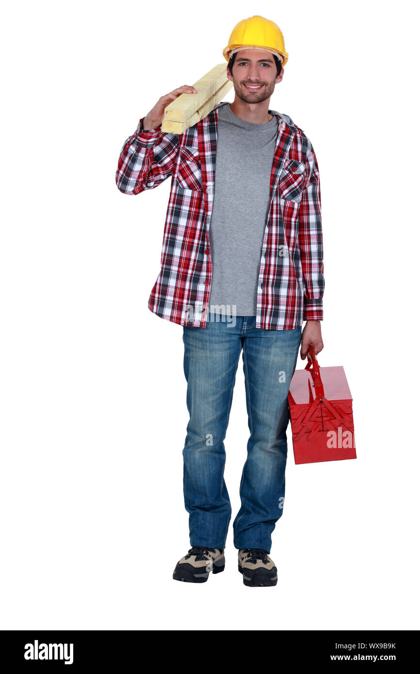 Workman carrying timber and a toolbox Stock Photo - Alamy