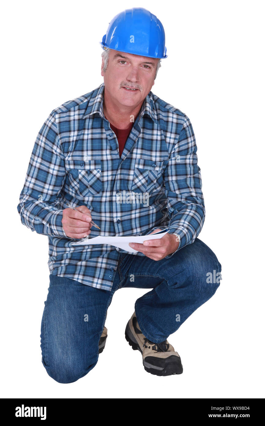 Builder writing on a piece of paper Stock Photo - Alamy