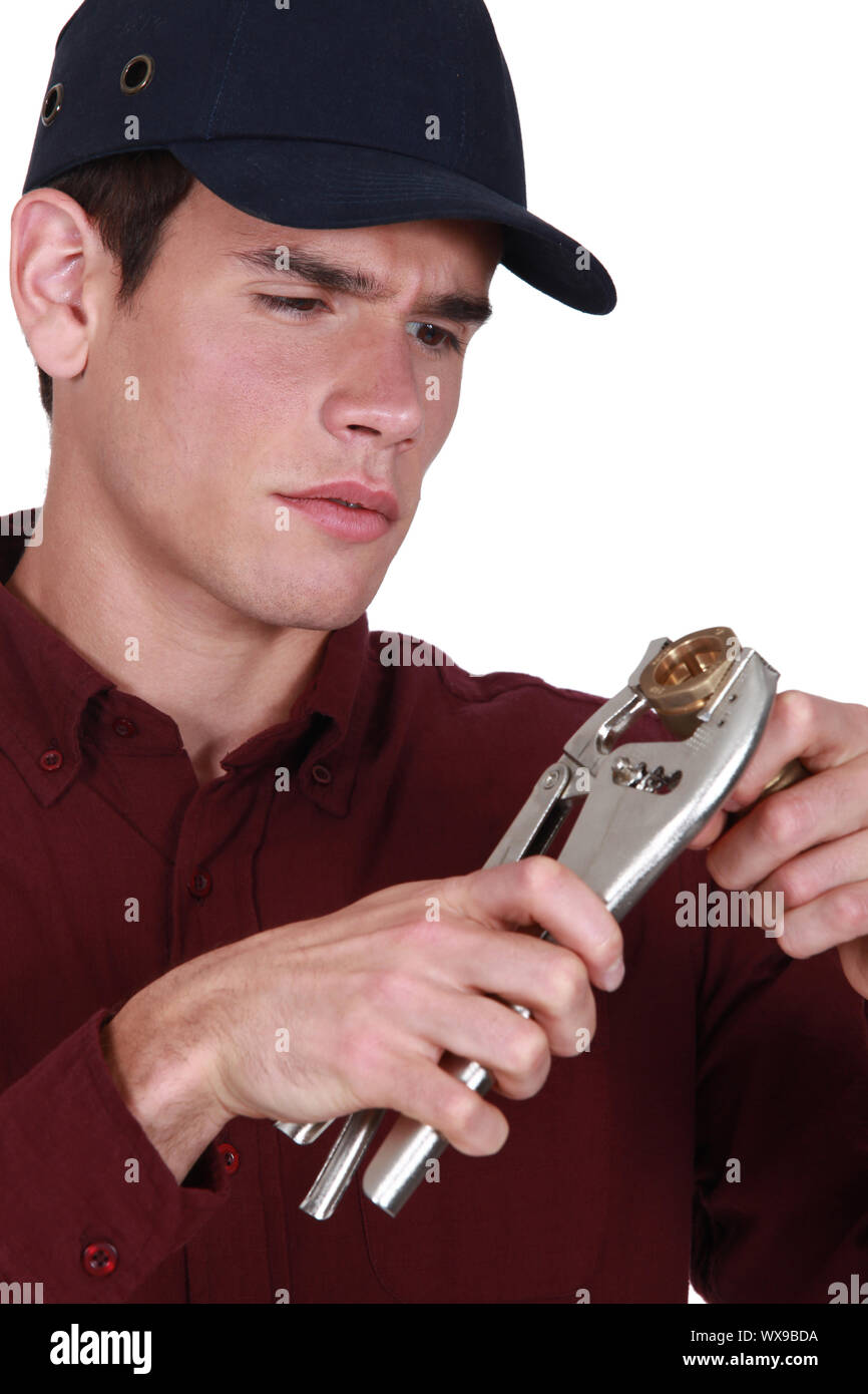 Plumber holding wrench and pipe Stock Photo - Alamy