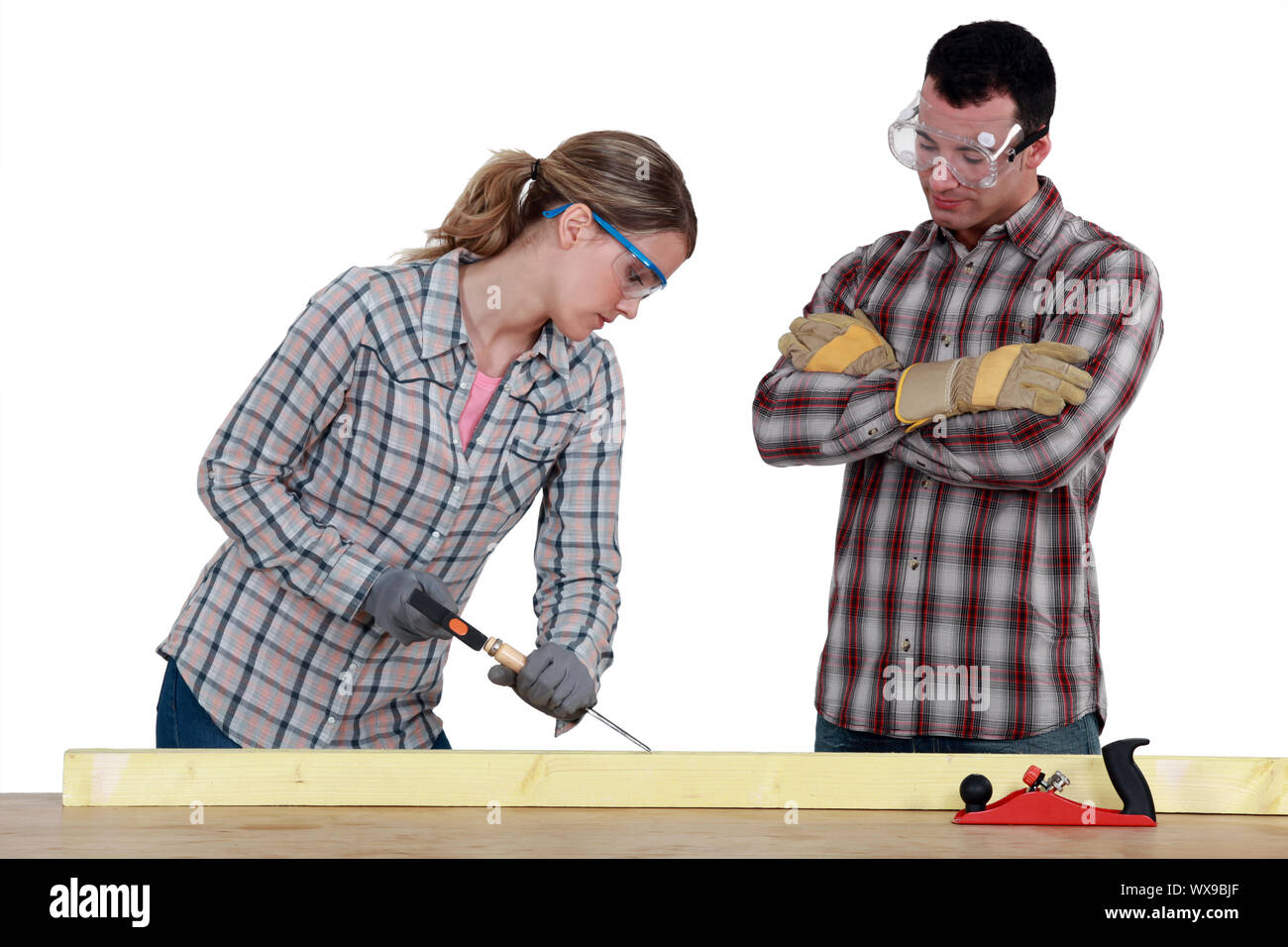 female carpenter at work with male workmate watching her Stock Photo ...