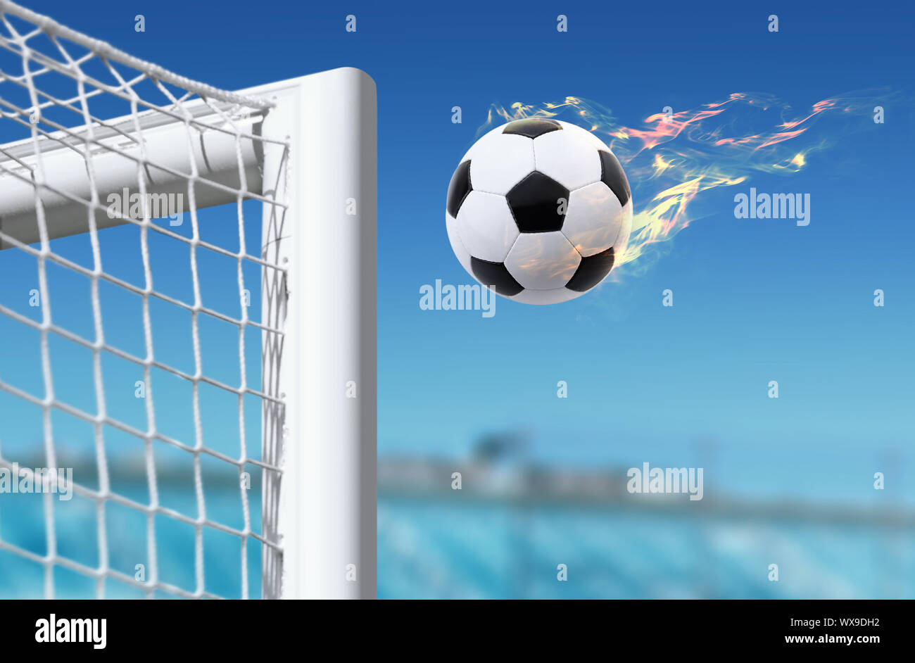 fiery football flies in goalkeeper gate on stadium Stock Photo - Alamy