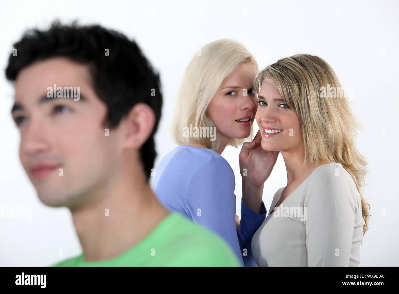 Two girls gossiping about man Stock Photo - Alamy