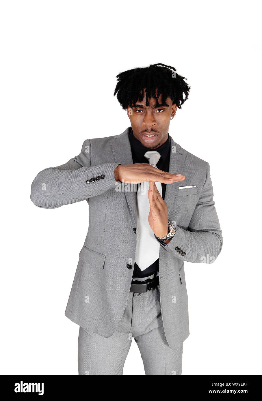 Young black man standing in a suit giving sign to talk Stock Photo - Alamy