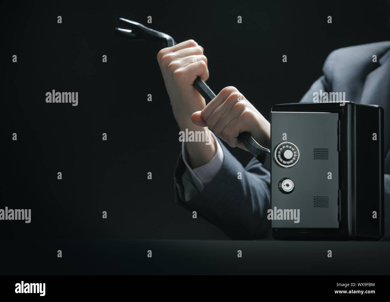Thief with a crowbar in the hands, trying to crack the safe Stock Photo ...
