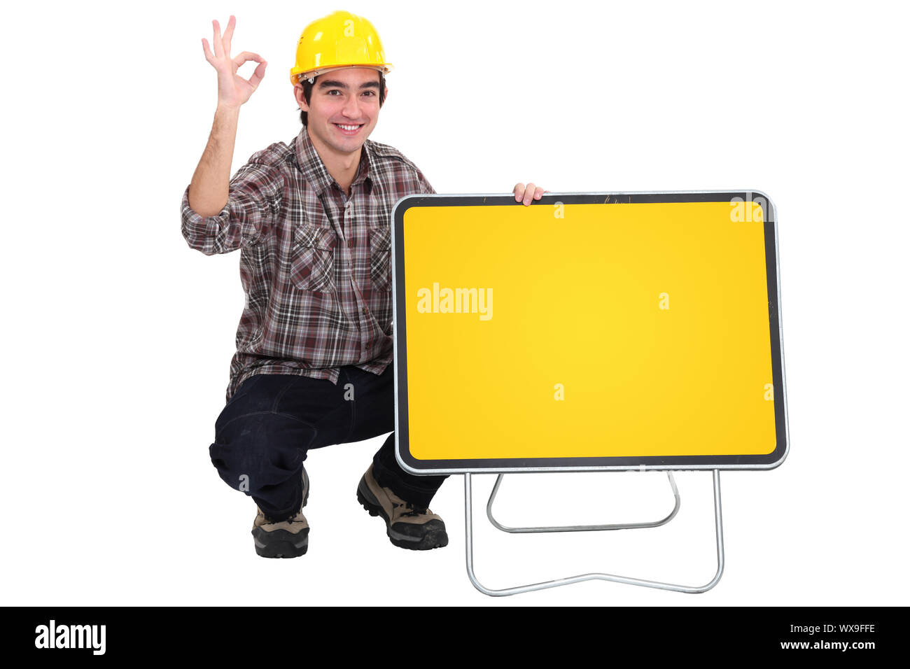 Workman with empty road sign for message Stock Photo - Alamy
