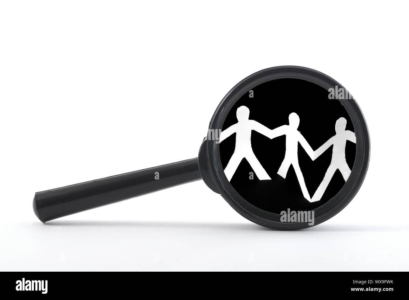 magnifying glass and team of paper man showing teamwork Stock Photo - Alamy