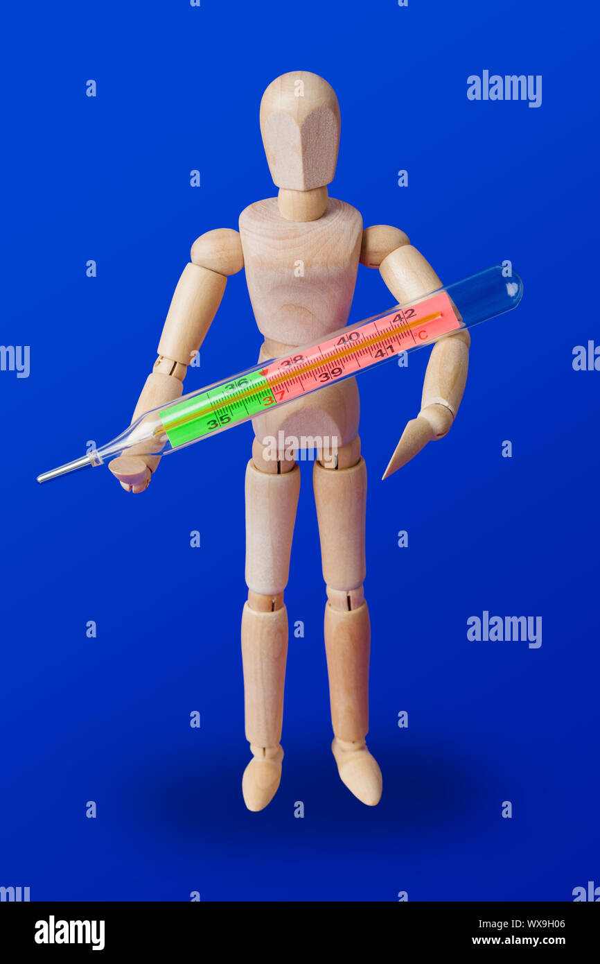Wooden toy figure with thermometer on blue Stock Photo - Alamy