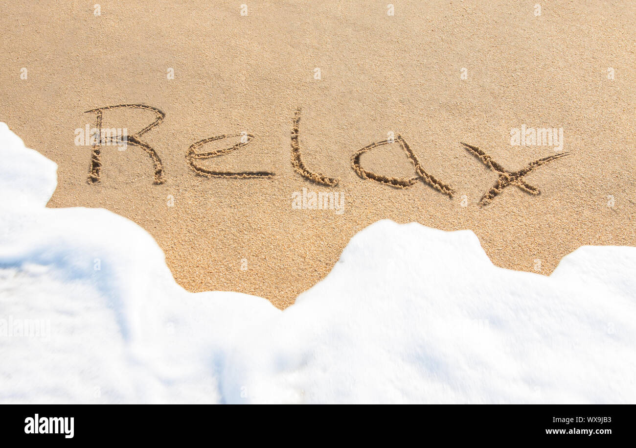 Relax - written in the sand with a foamy wave underneath Stock Photo ...