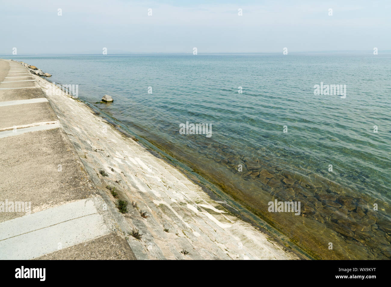 beautiful lake shore nature view with concrete embankment and wall ...