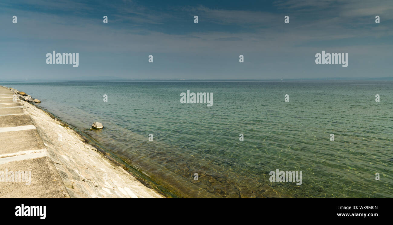 beautiful lake shore nature view with concrete embankment and wall ...