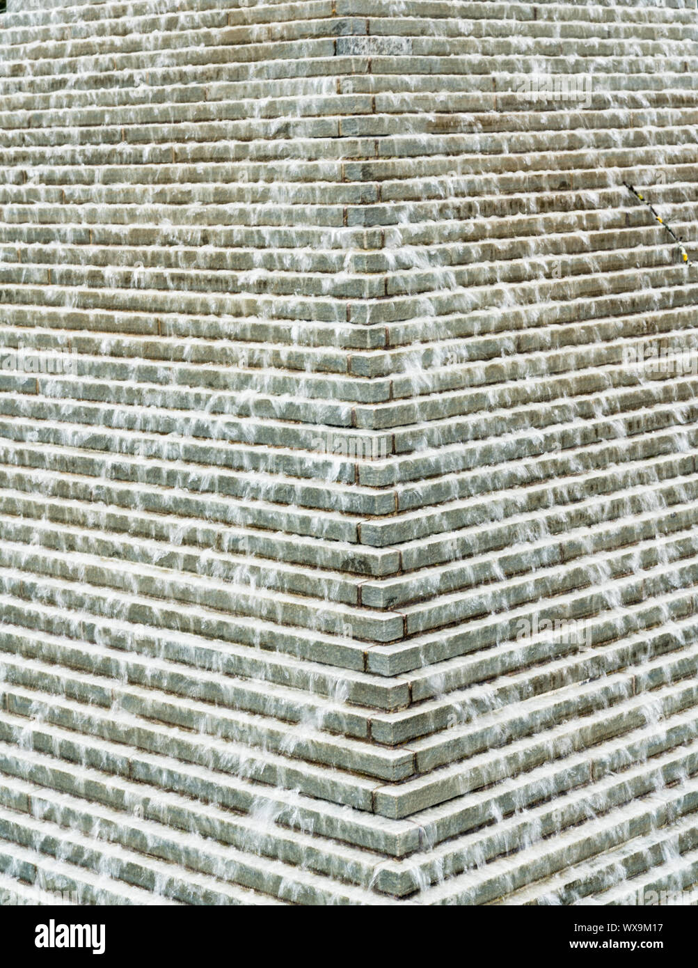 abstract view of an artsy water fountain pyramid with water flowing and ...