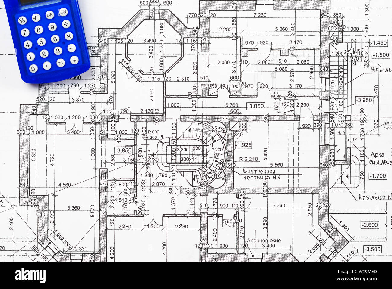 Calculator over house plan blueprints Stock Photo - Alamy