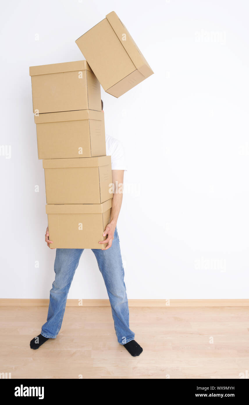 Young man carrying and dropping his stack of moving boxes Stock Photo ...