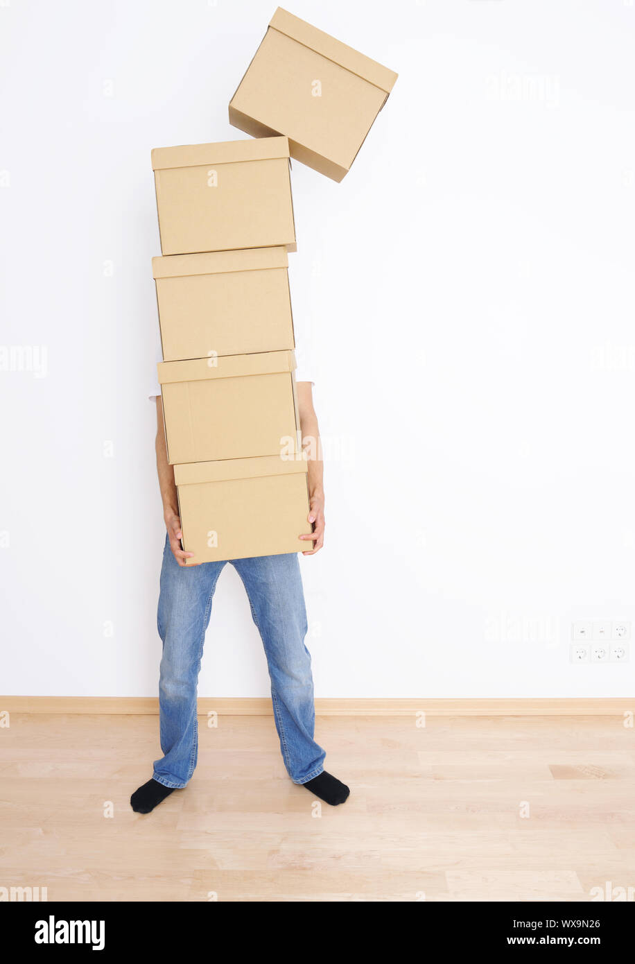Young man carrying and dropping his stack of moving boxes Stock Photo ...