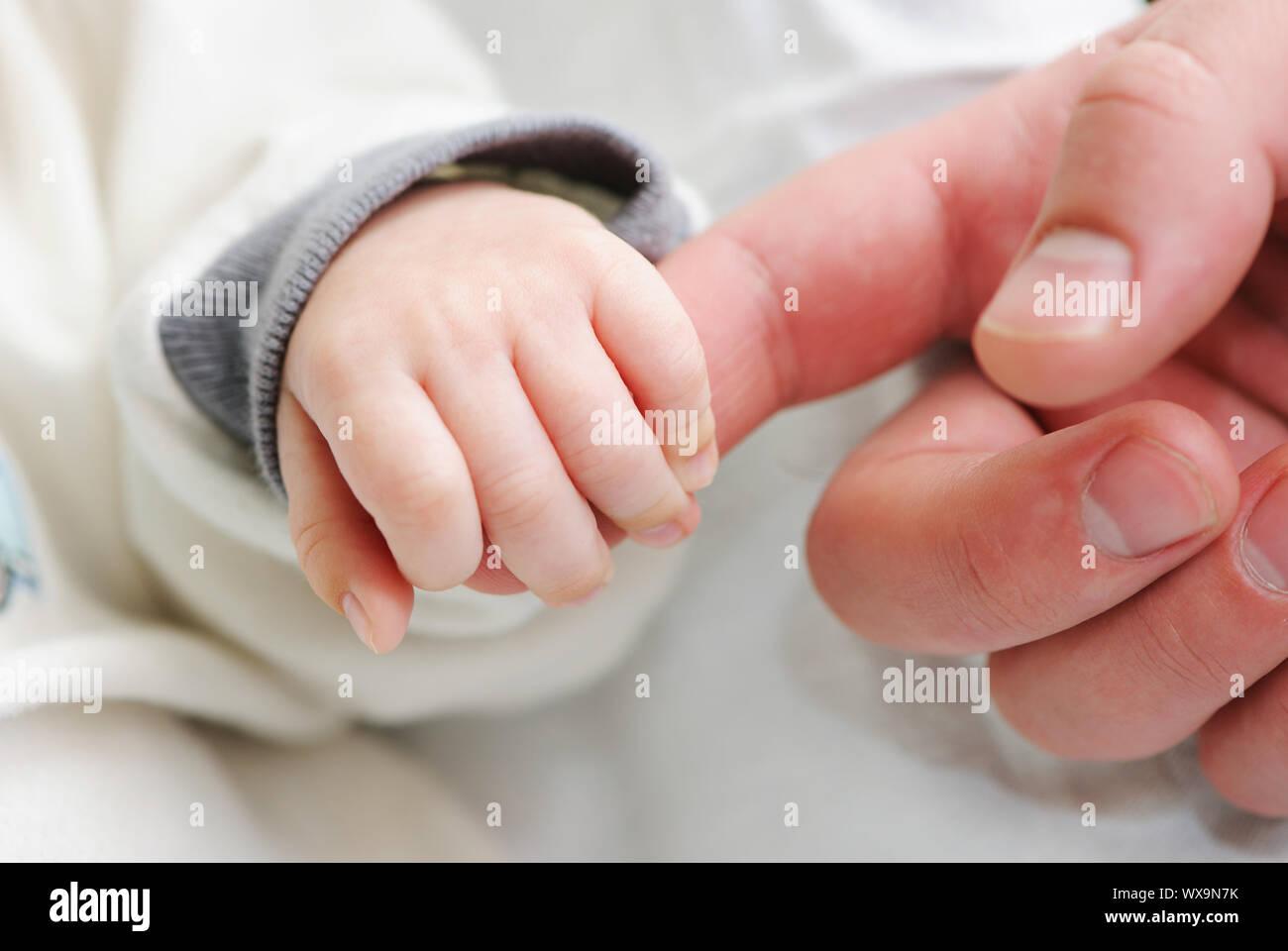 Newborn baby holding father's finger Stock Photo - Alamy