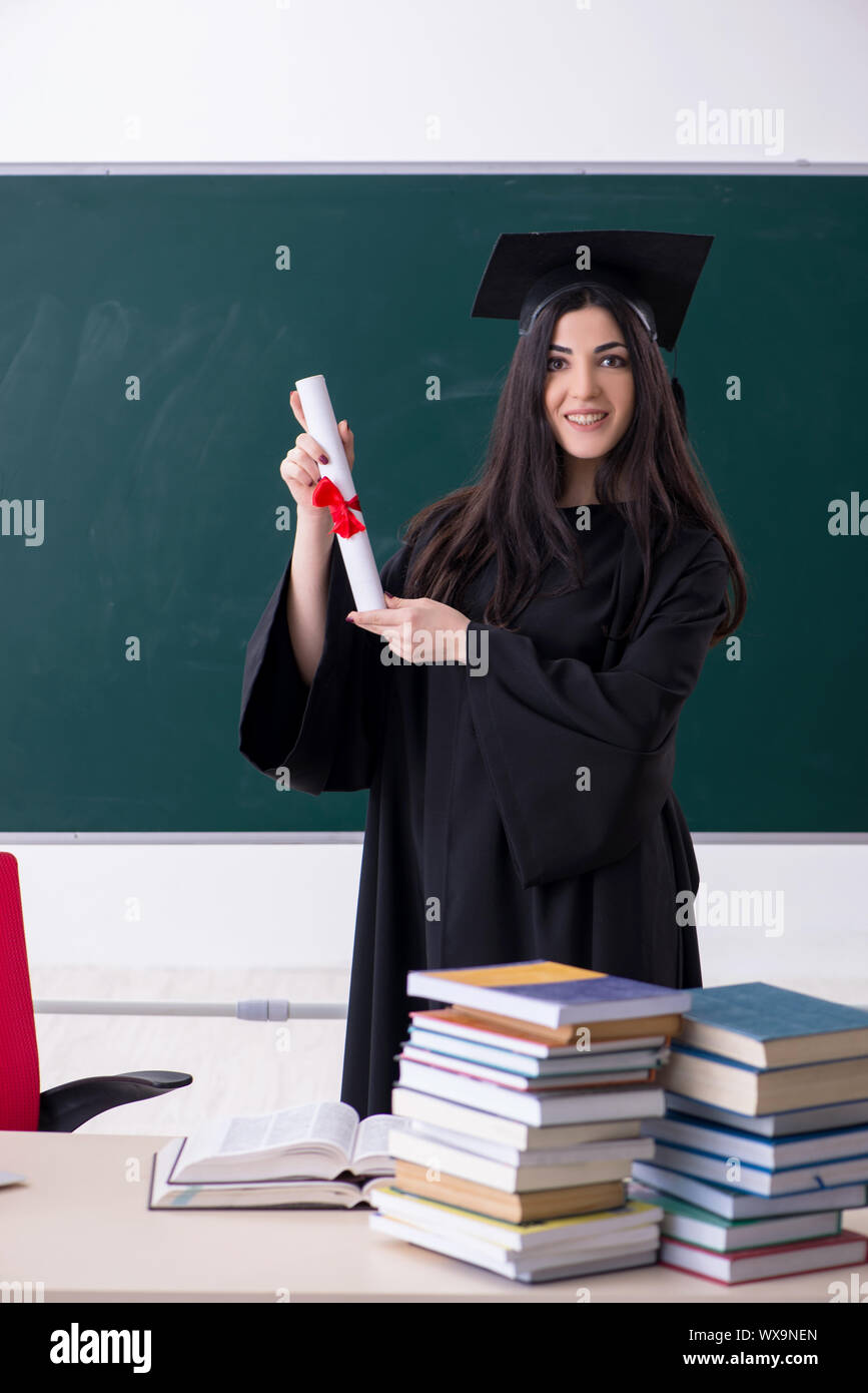 Female graduate student in front of green board Stock Photo - Alamy