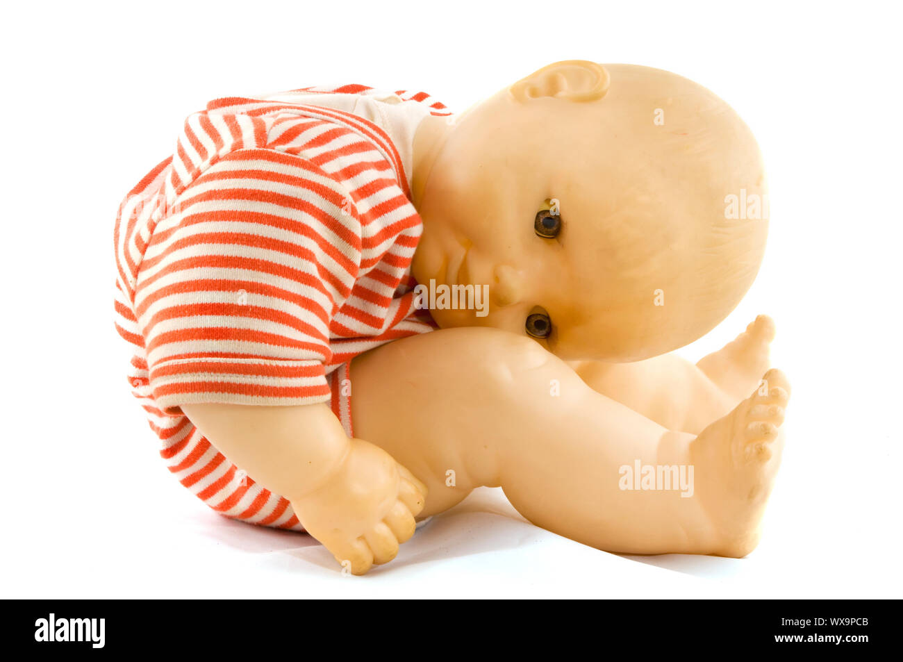 Little baby doll sitting Stock Photo - Alamy