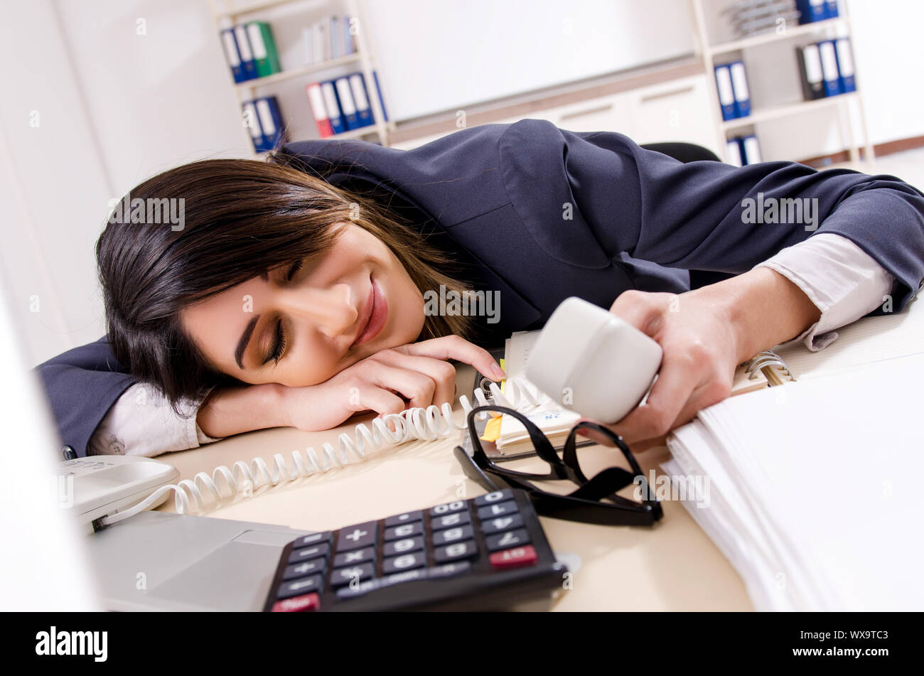 Young female employee sleeping in the office Stock Photo - Alamy