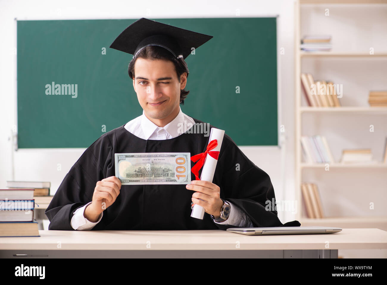 Graduate student in front of green board Stock Photo - Alamy
